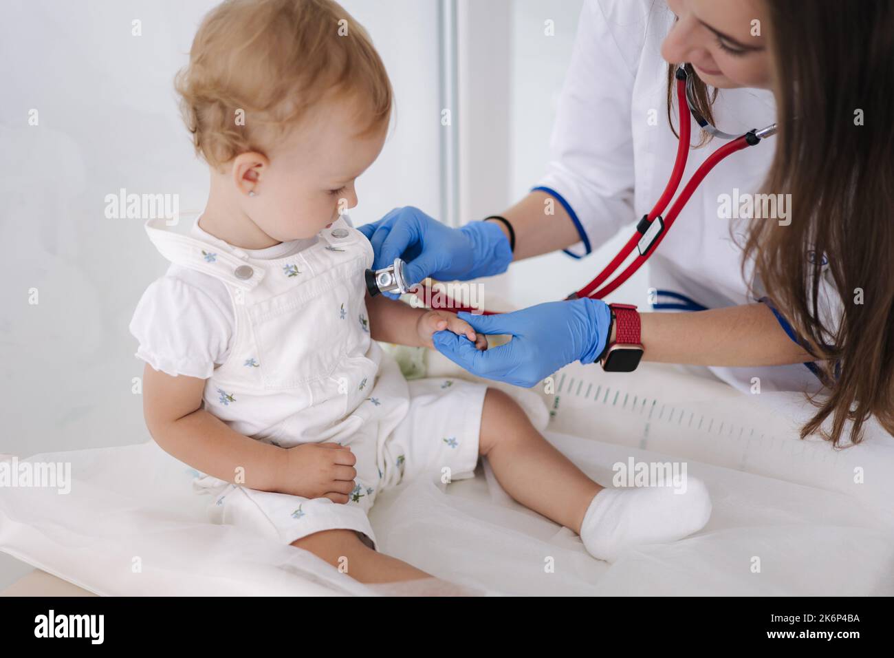 Female doctor checking child's lungs during checkup at home. Woman ...