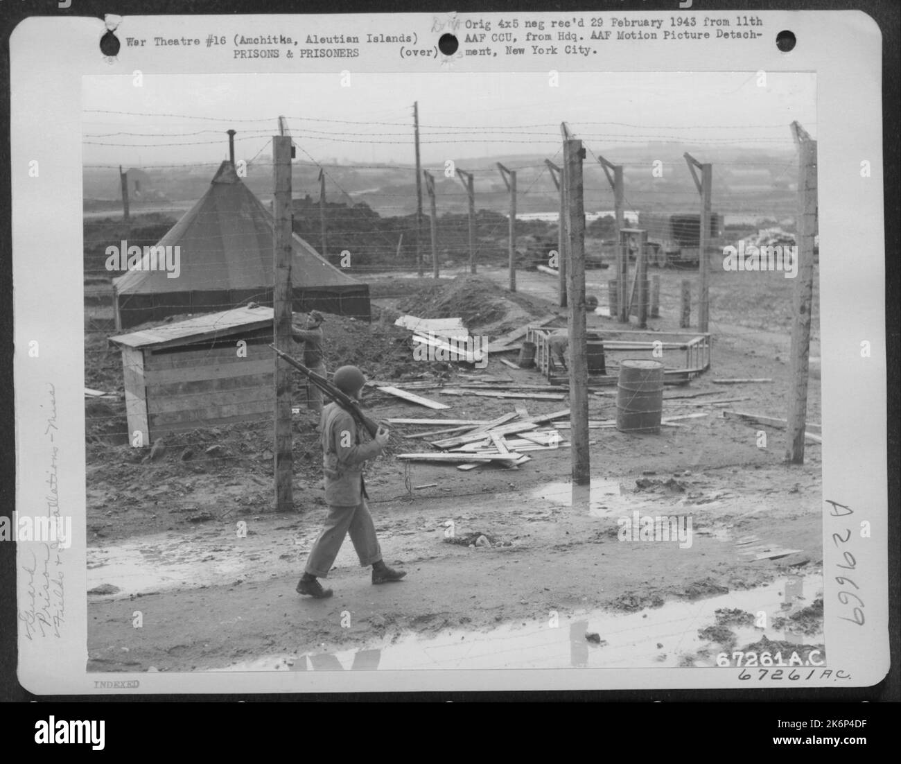 A guard walks his post around the stockade at an 11th Air Force base in ...