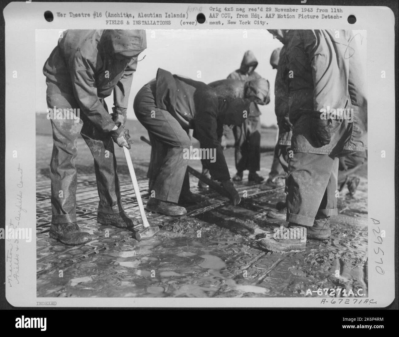 Men putting strips of marston mat together for construction of runway ...
