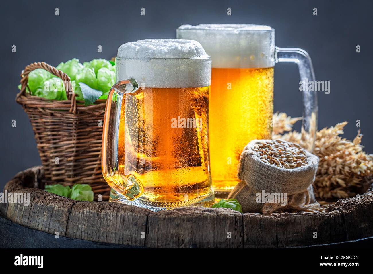 Cold and gold light beer on wooden barrel. A golden light beer in a mug ...