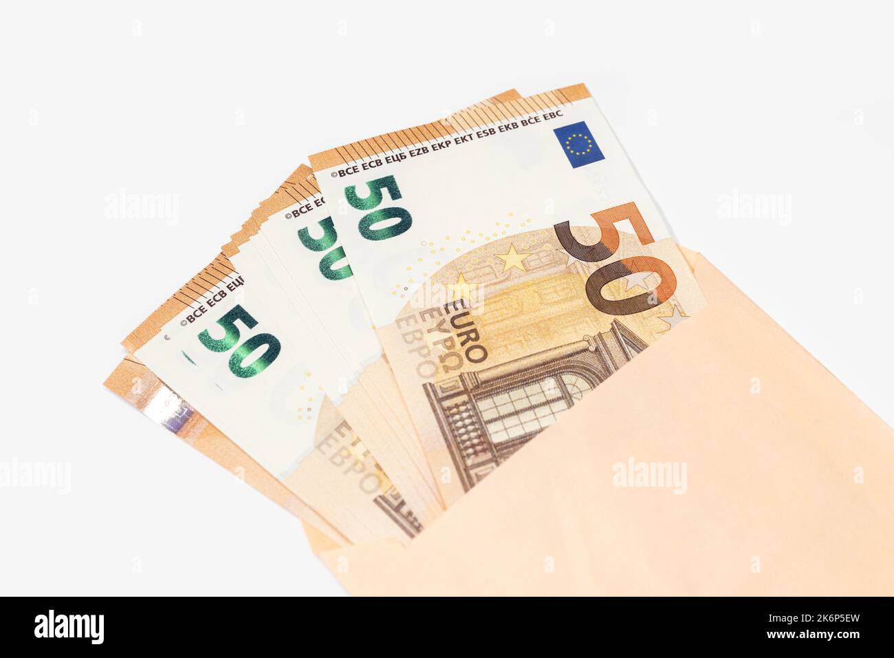 Group of 50 euro banknotes coming out of an envelope on white ...