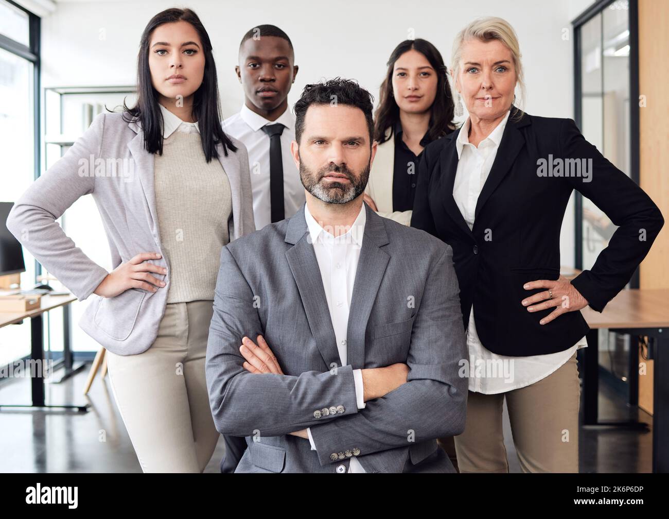 We can do any job. a group of businesspeople standing in an office at ...