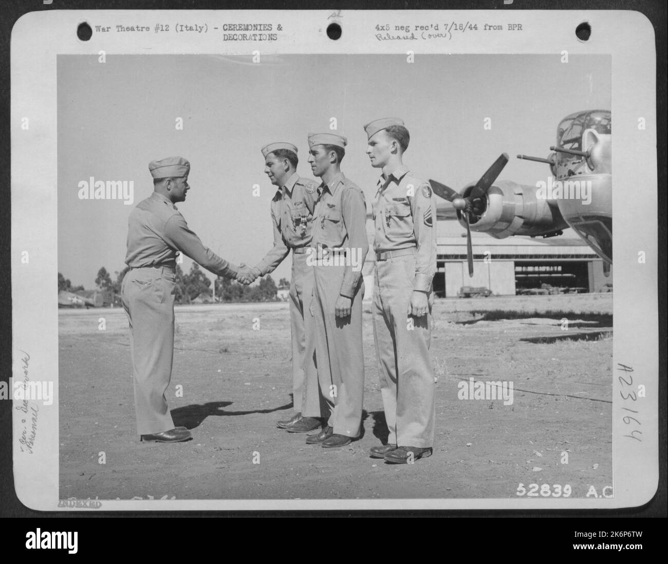 ITALY-Col. H.P. Rush, Wing Commanding Officer, congratulates three men ...