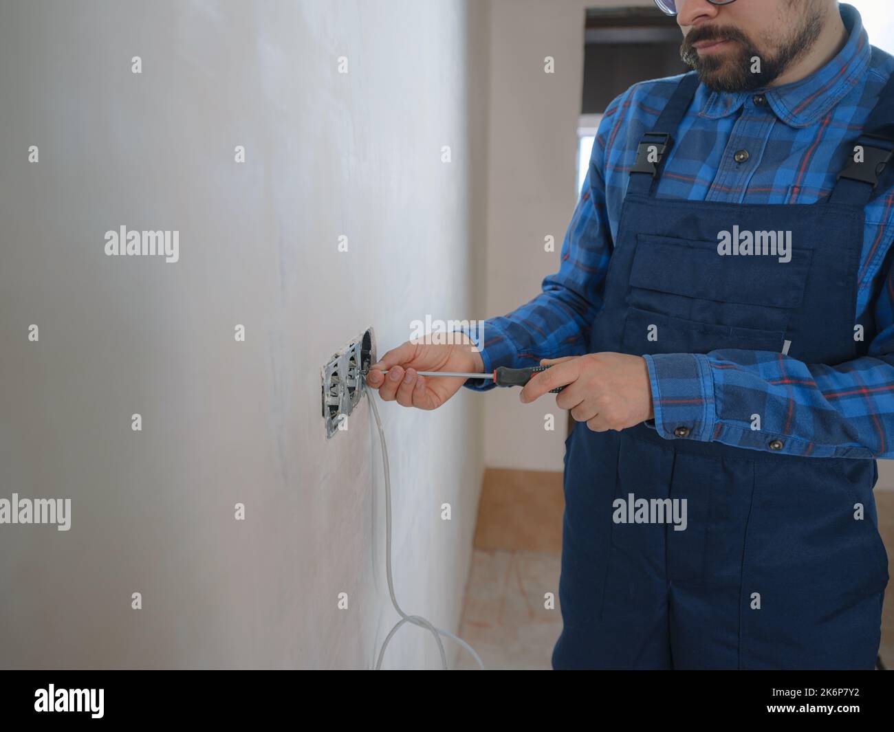 young man in blue work suit doing Repair apartment. Home renovation ...