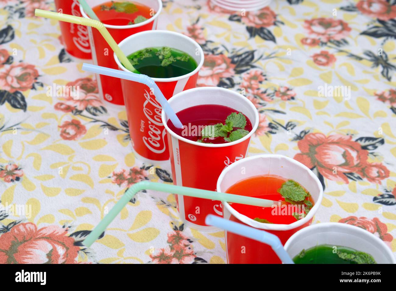 Herbal juice poured in a Coca-Cola branded cup and displayed on a table ...