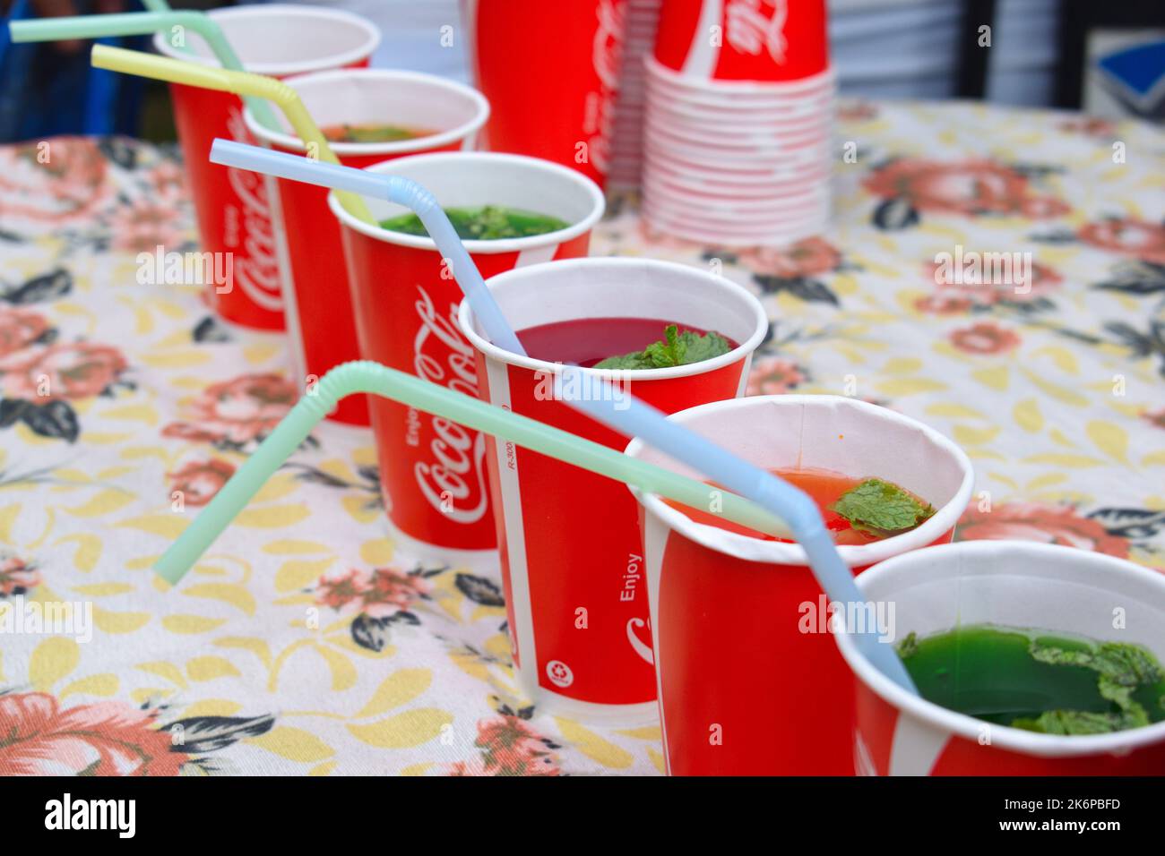 Herbal juice poured in a Coca-Cola branded cup and displayed on a table ...
