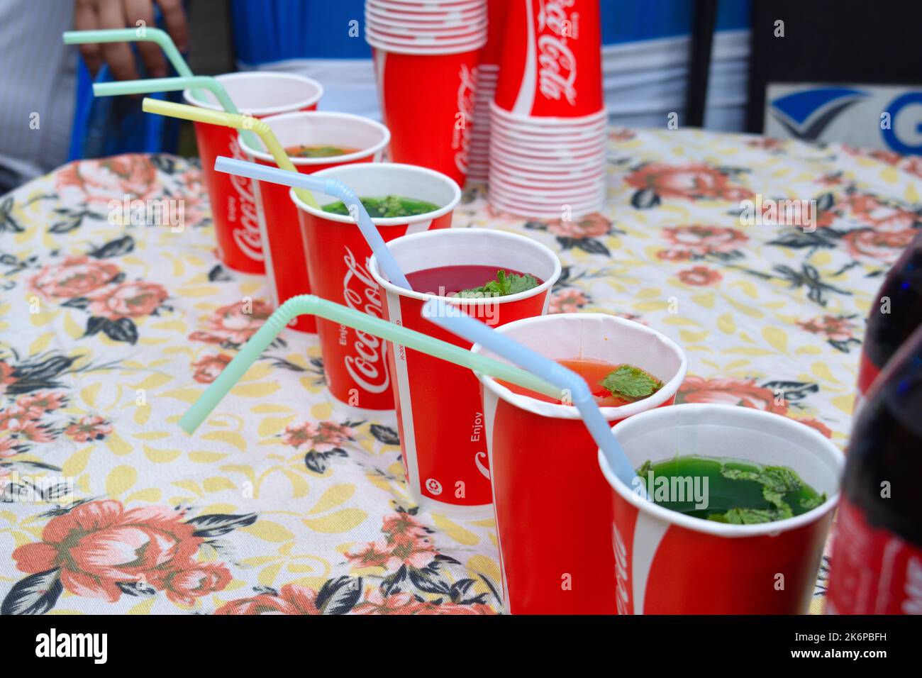Herbal juice poured in a Coca-Cola branded cup and displayed on a table ...