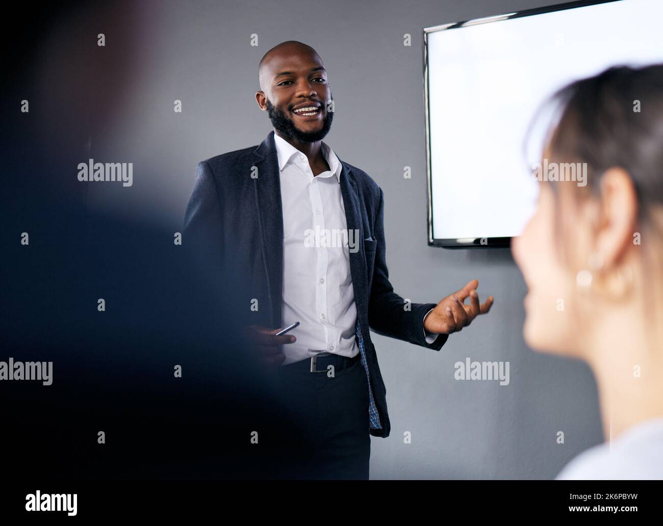 Teamwork begins by building trust. an young businessman giving a ...