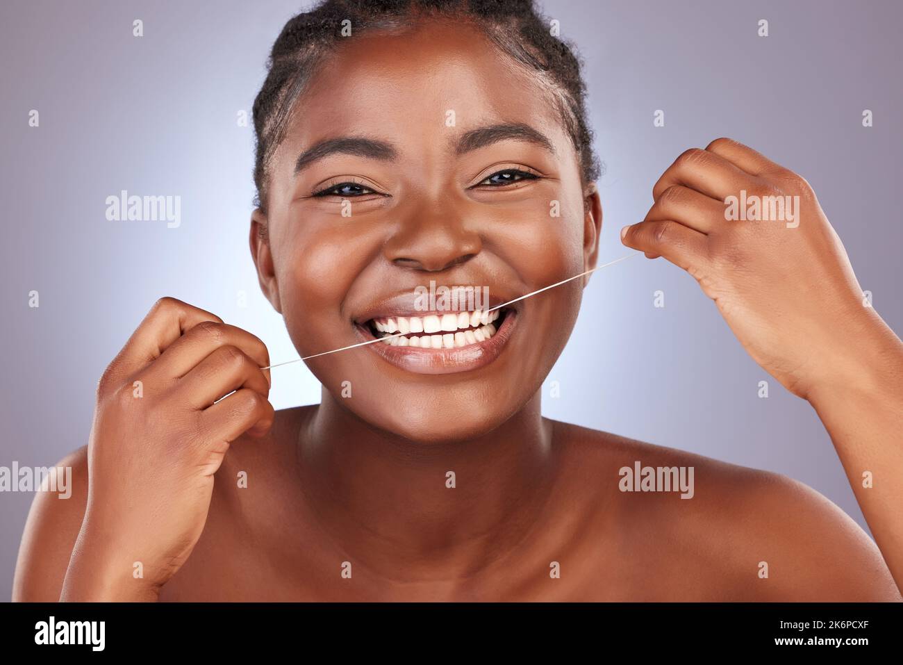 Keep it clean and flossed. a young woman flossing her teeth while ...
