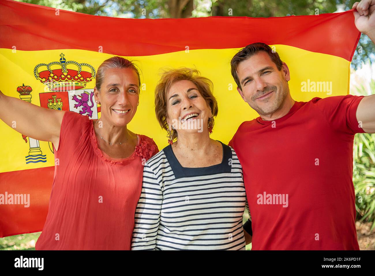 A middle-aged boy and a middle-aged girl next to an older lady raising ...