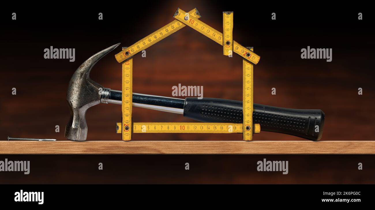Wooden folding ruler in the shape of house and a steel hammer with ...