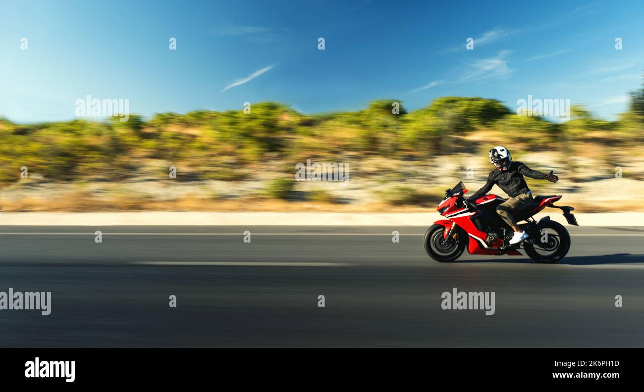 Side view of a motorcycle rider riding red race motorcycle on the ...