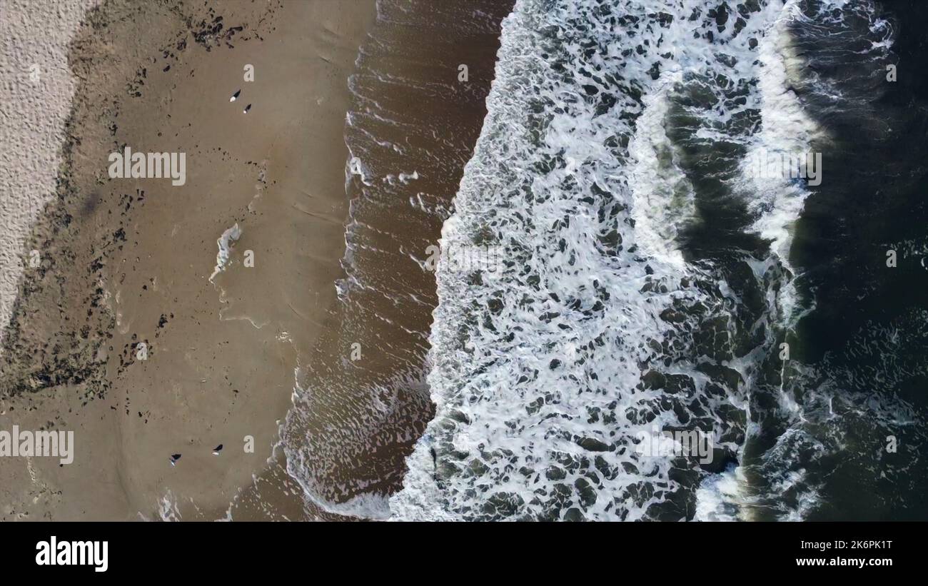 Aerial drone view flight over sea waves that roll onto sandy shore. Top ...