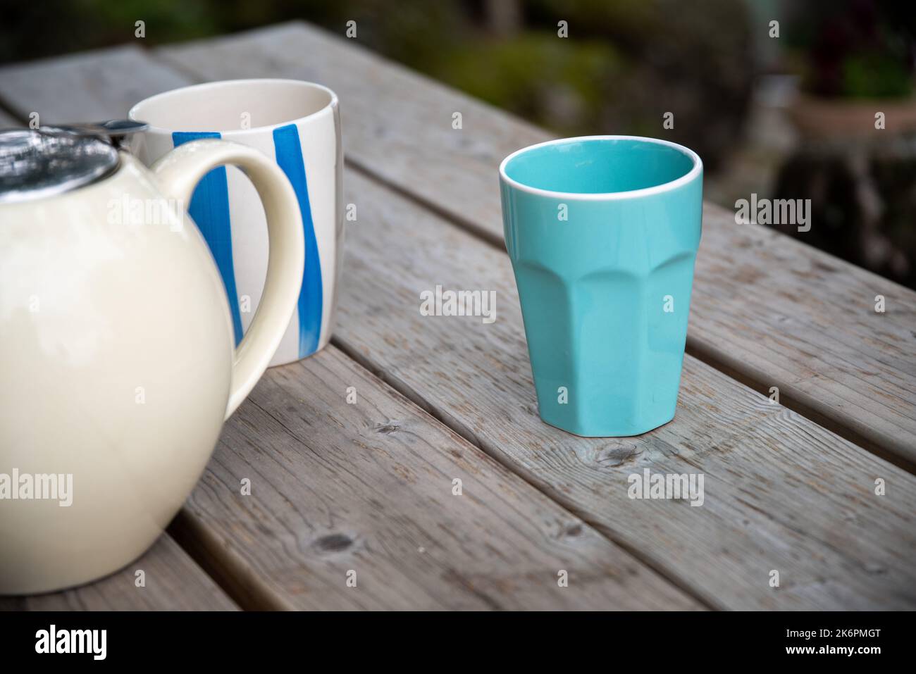 Mug and teapots on wooden table Stock Photo - Alamy