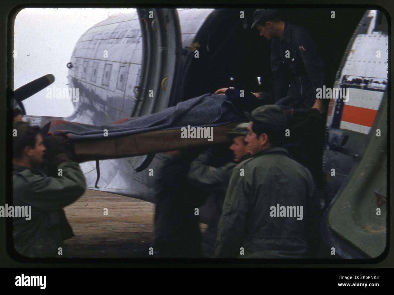 Four medics transport wounded soldier on a stretcher onto or off a ...
