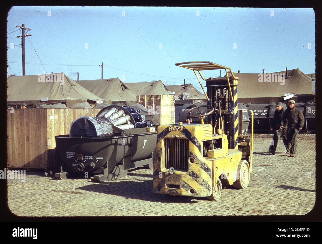 An engine in its shipping container sitting next to a forklift.. An ...