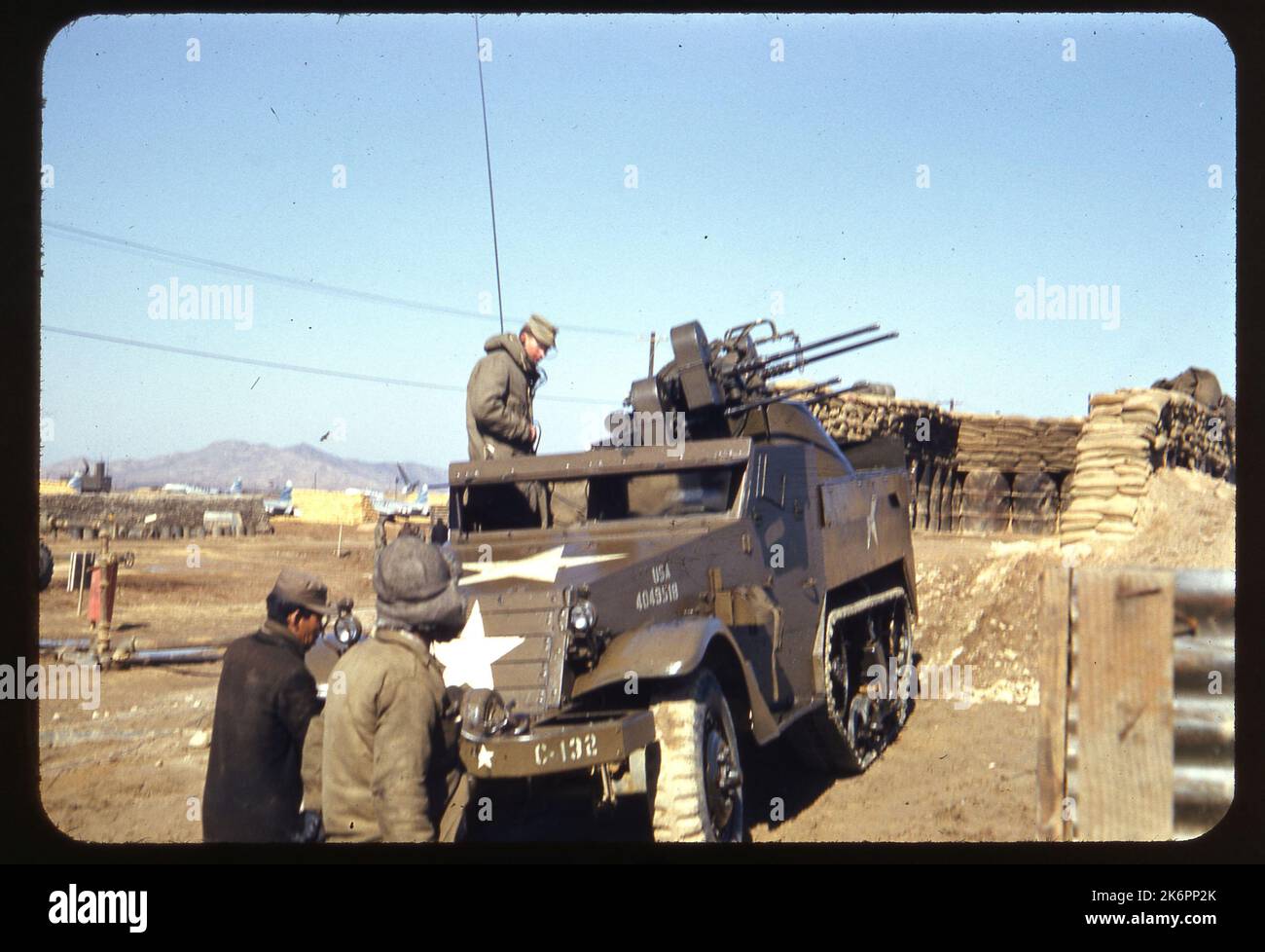 Three-quarter left front view of an M-16 GMC (halftrack) with crewman ...