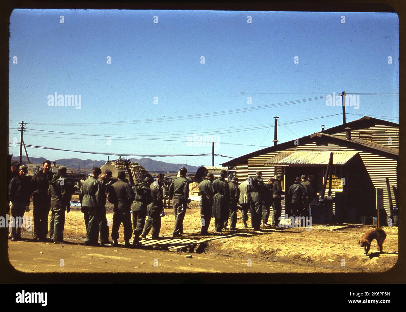 Photo of men lined up to enter building.. Photo of men lined up to ...