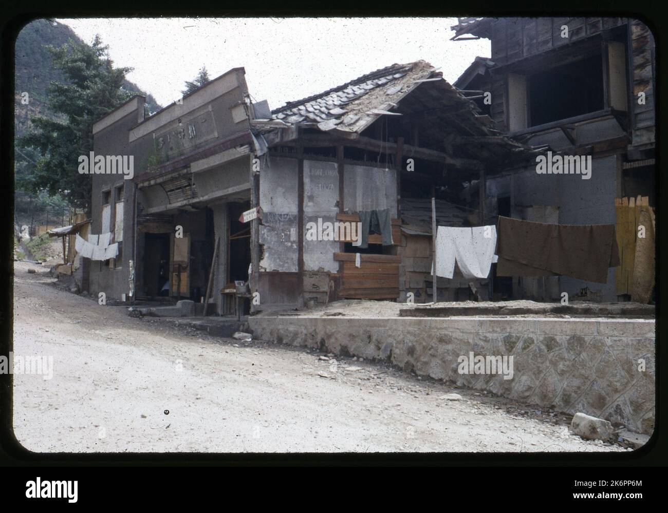 Street view of buildings damaged by bombs. Laundry line with clothes ...