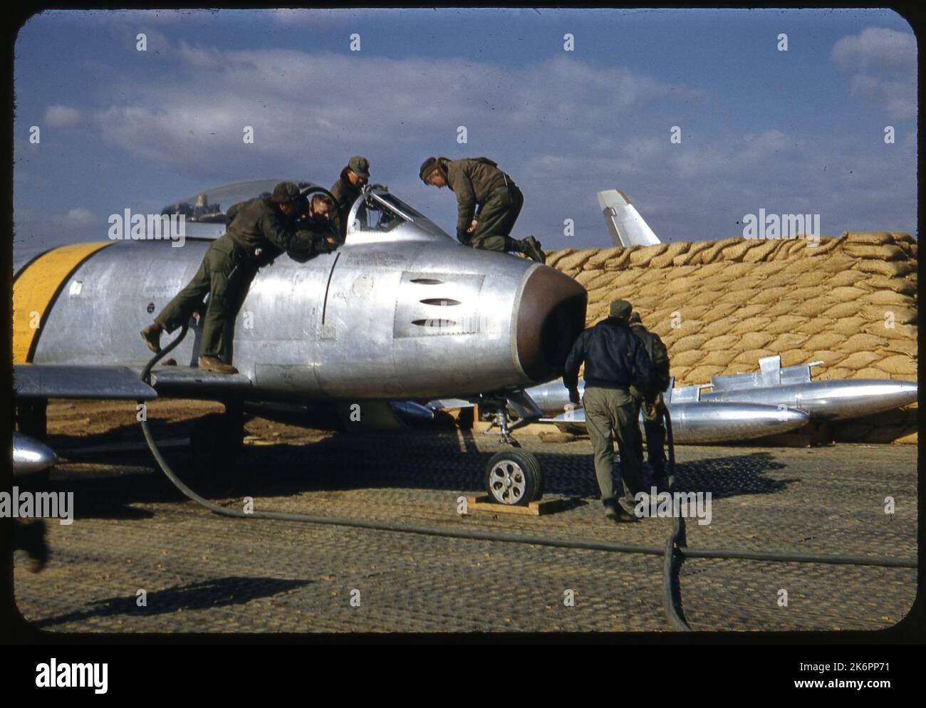 Right side view of a North American F-86 Sabre. Three technicians ...