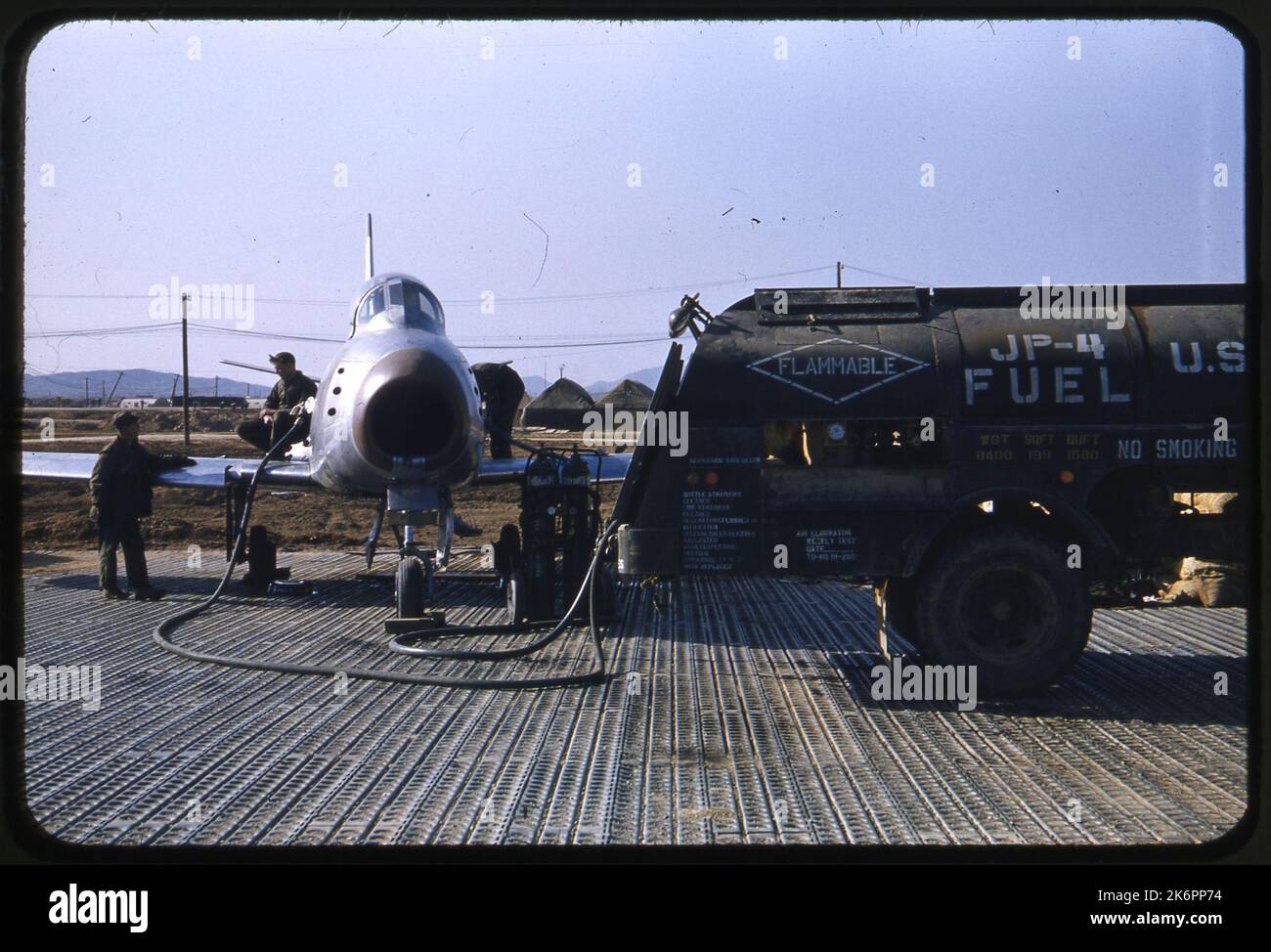 Front view of a north American F-86 Sabre jet being refueled. Half of ...