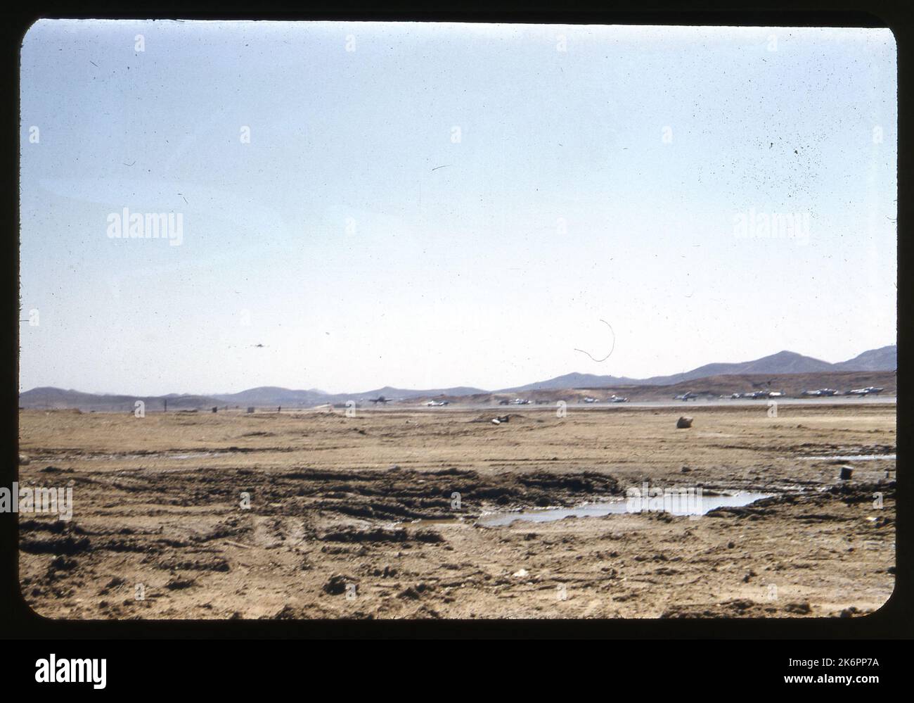 View of mud. Runway with plane in background.. View of mud. Runway with ...