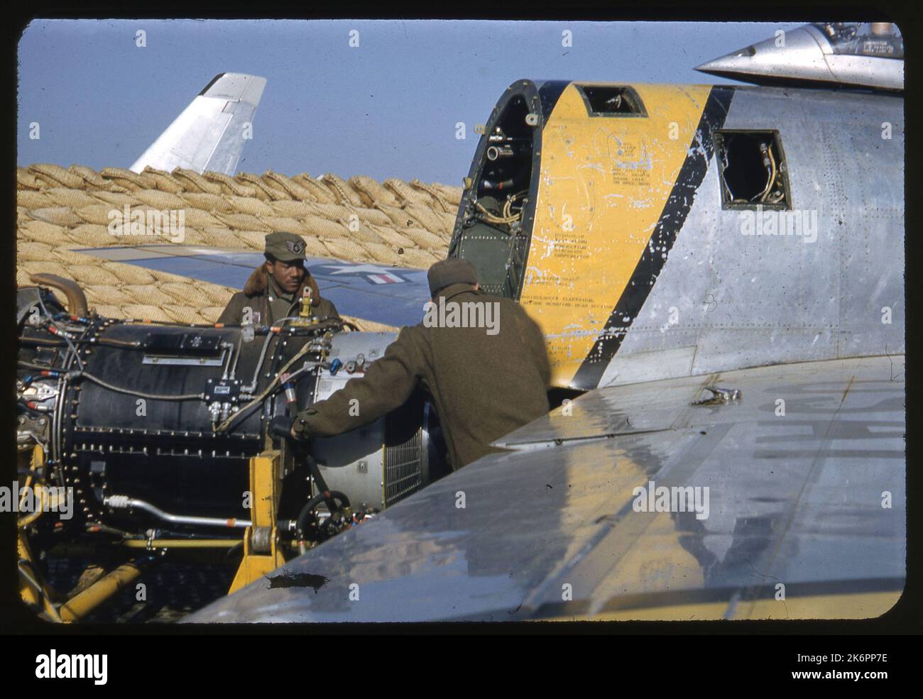 Two technicians prepare to do something with the engine of a North ...