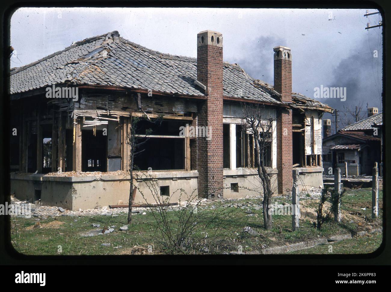 Picture of a house falling apart. Roof slightly torn up, windows gone ...
