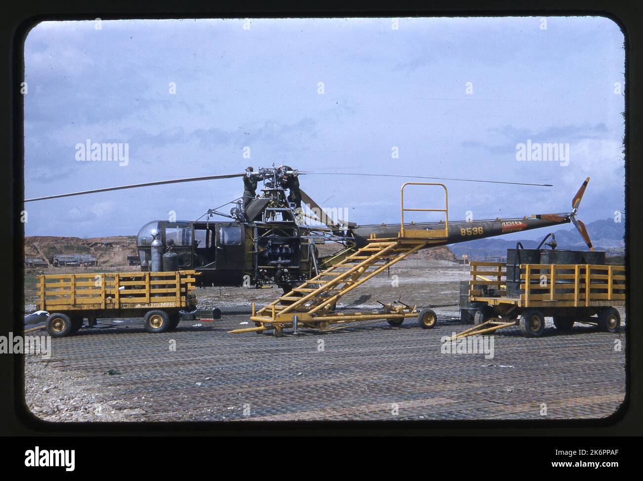 Two technicians examine the engine of a Sikorsky H-5G Dragonfly (s/n 48 ...