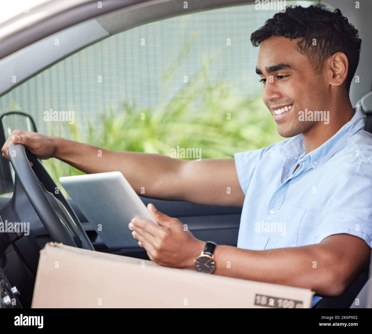 Processing your package with a smile. a young delivery man using a ...