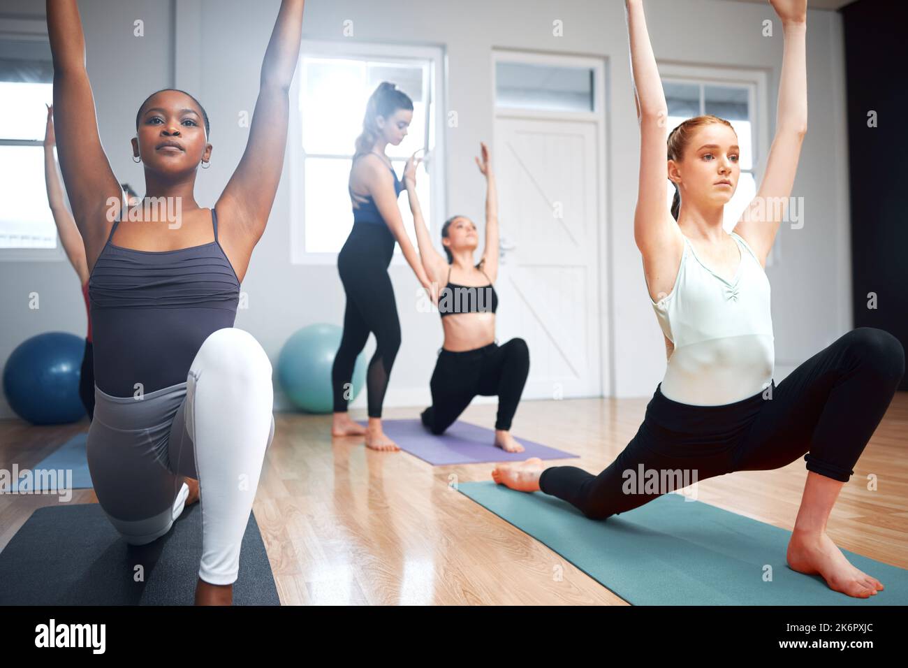 Steady yourself by gazing forward. a group of yoga students completing ...