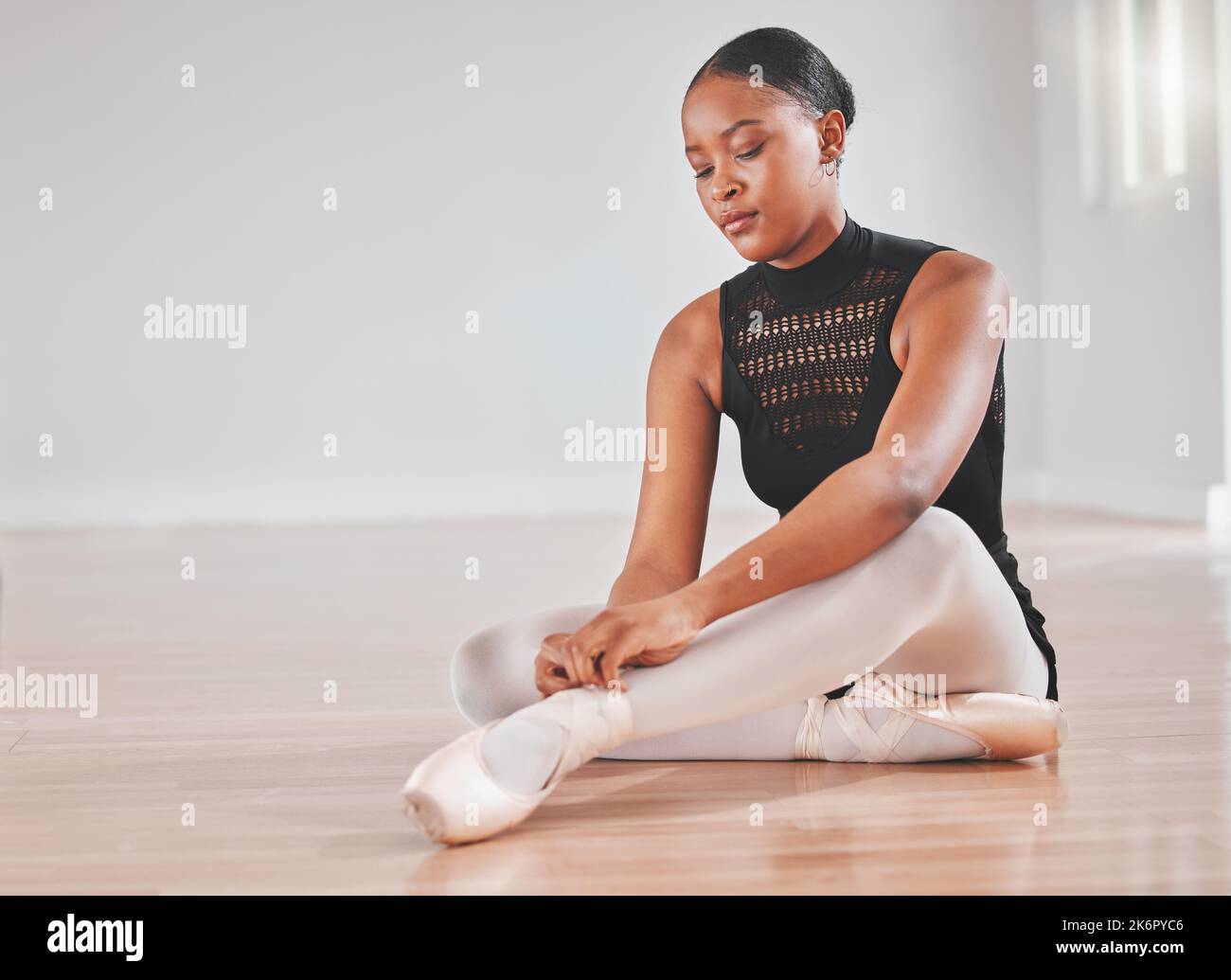 Put on your shoes and let the show begin. a young ballet dancer tying ...