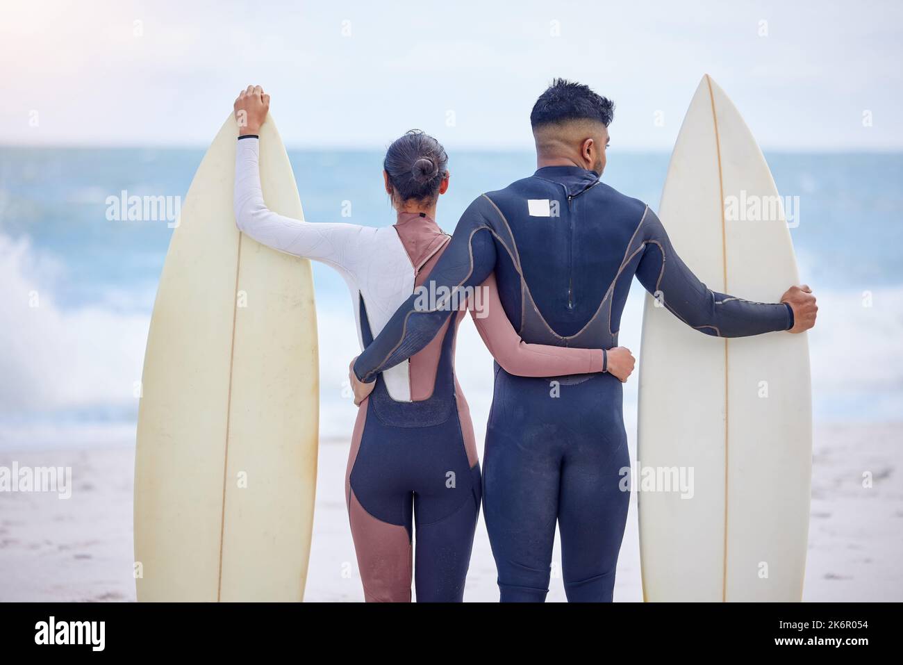 Wont you ride with me forever. Rearview shot of a young couple surfing ...