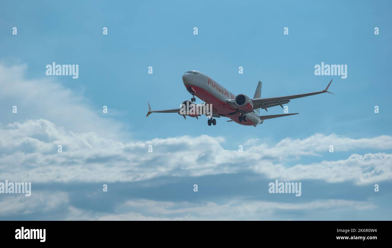 Airplane flying in a blue sky Stock Photo - Alamy