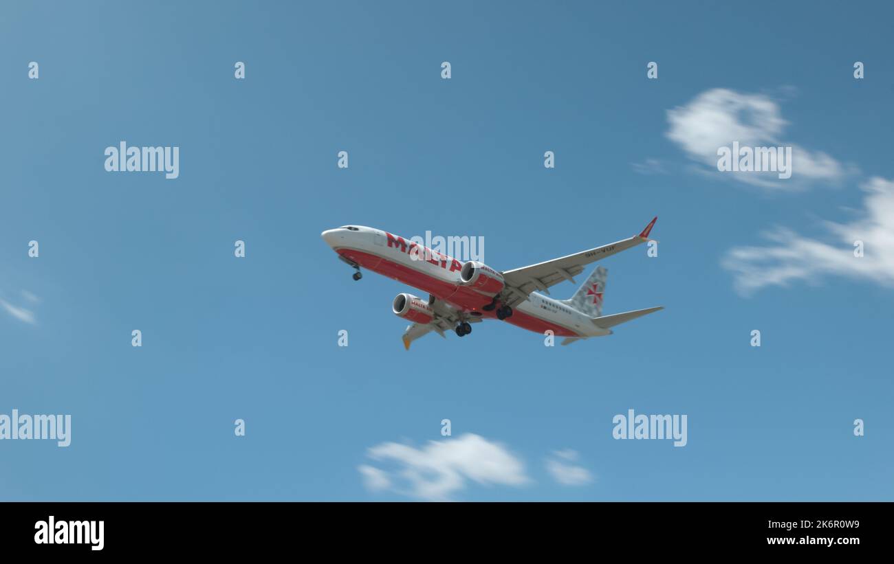 Airplane flying in a blue sky Stock Photo - Alamy