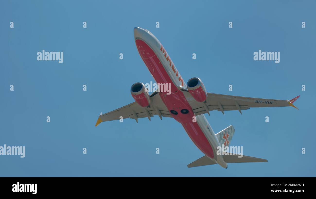 Airplane flying in a blue sky Stock Photo - Alamy