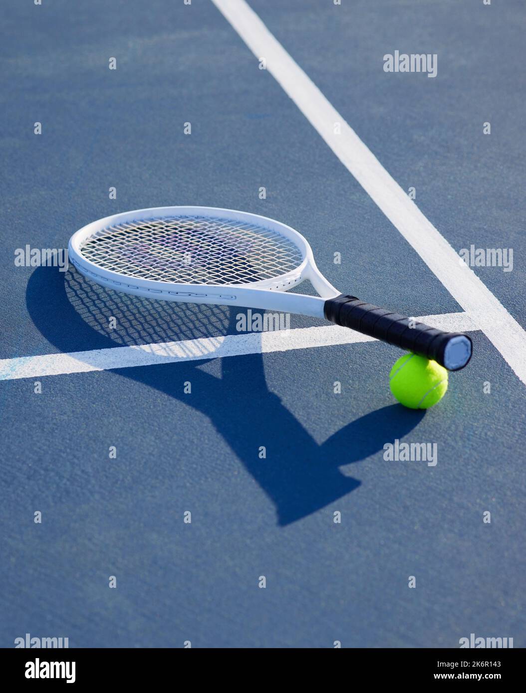 Pick it up. a tennis rackets and tennis balls on a court during the day ...