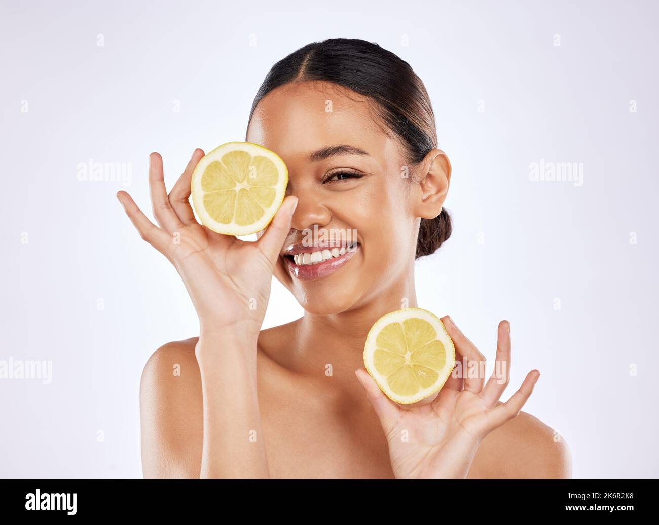 One lemon away from clear skin. a beautiful young woman covering her ...