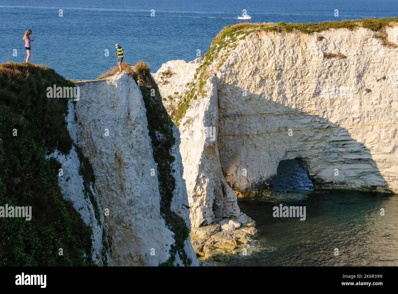 Youths walking on dangerous narrow clifftop footpath, Old Harry Rocks ...