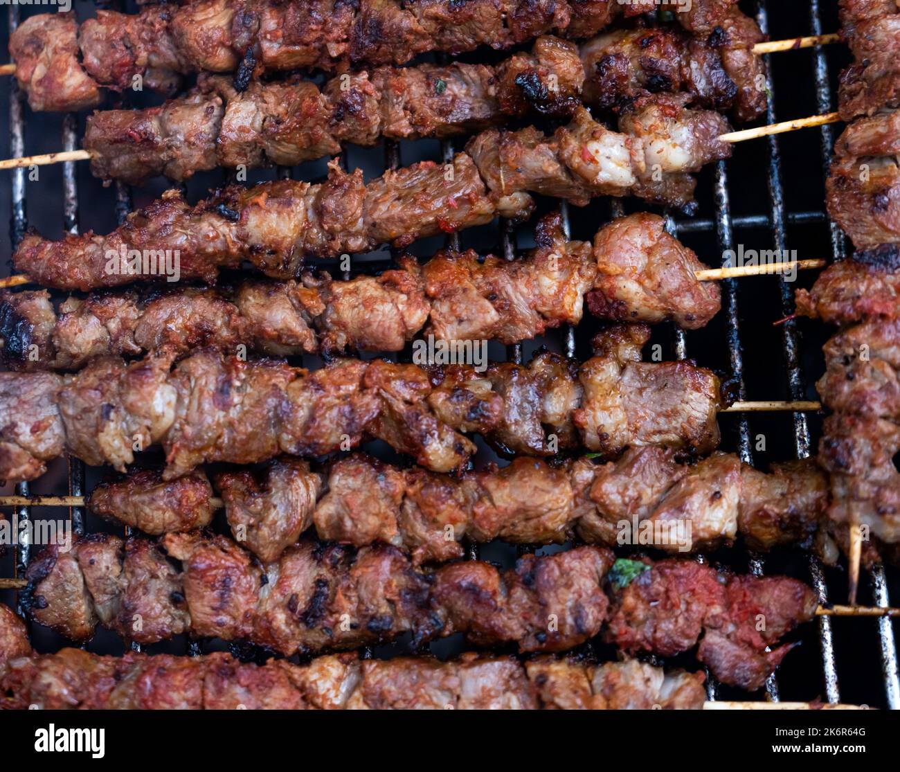 hot grilled lamb meat on skewers barbecued on open fireplace during a ...