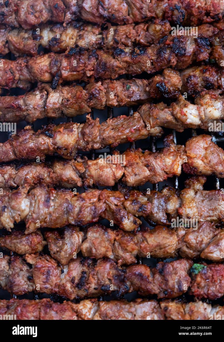 hot grilled lamb meat on skewers barbecued on open fireplace during a ...