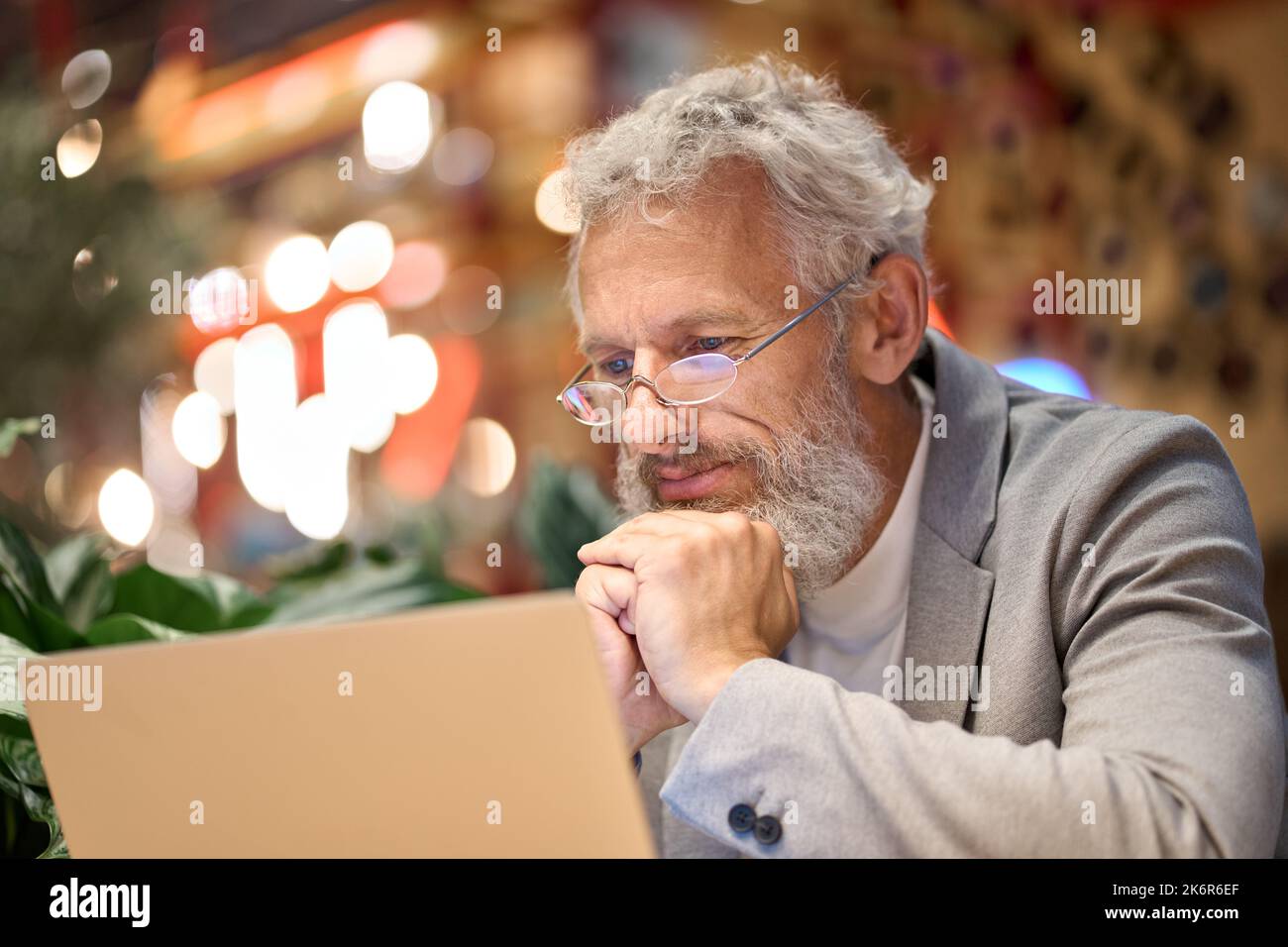 Older business man wearing eyeglasses looking at laptop watching webinar Stock Photo - Alamy