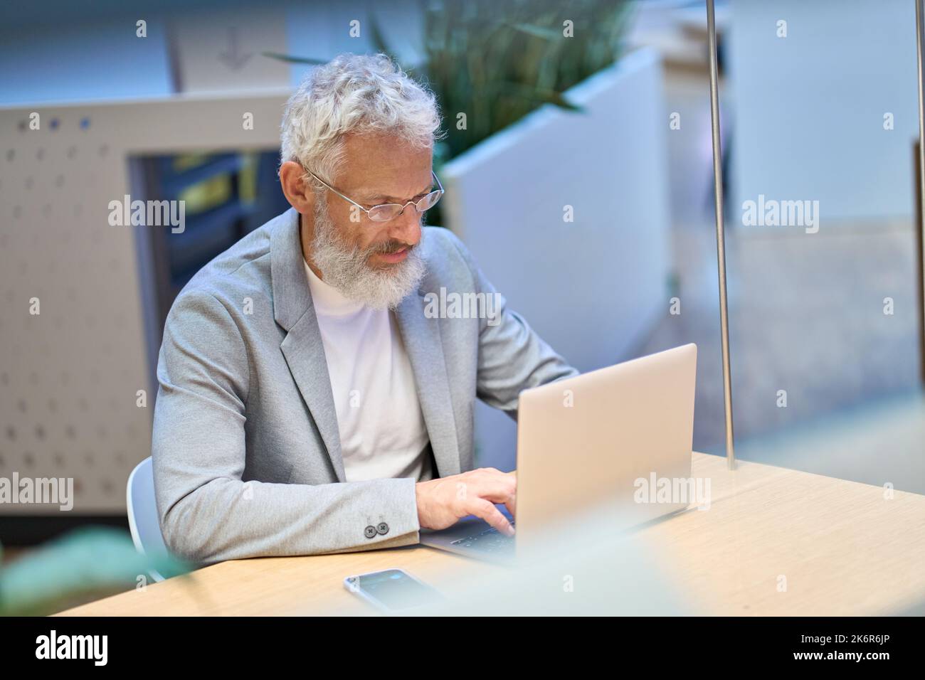 Busy older senior business man office worker using laptop sitting at ...