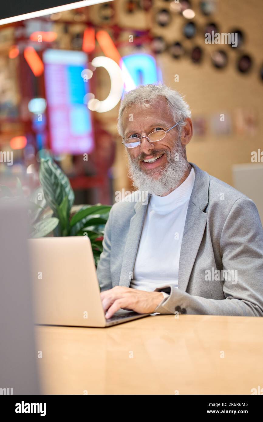 Happy old senior business man using laptop working late on computer ...