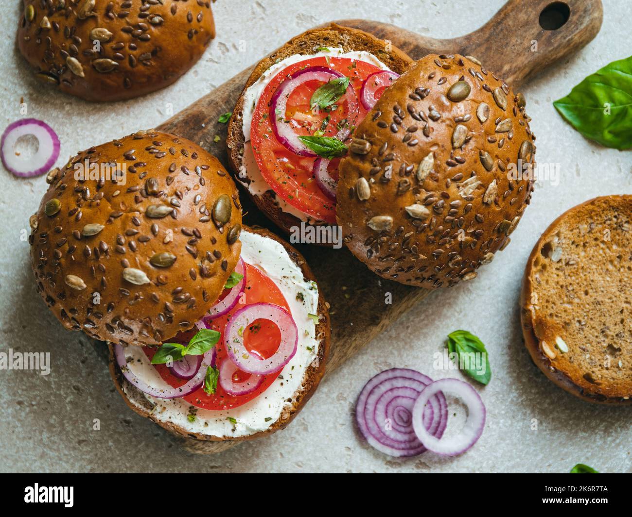 Top view of rye bread rusted buns with cream cheese, fresh tomato ...