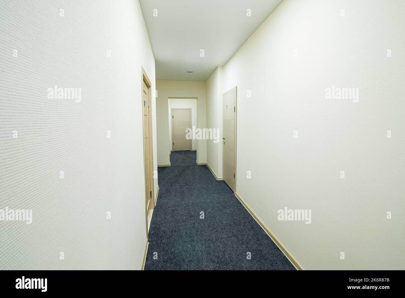 Long bright corridor with doors in a new hotel, hostel Stock Photo - Alamy