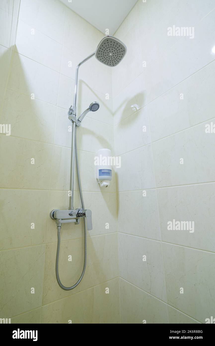 Bright bathroom with shower, shower head, light tile Stock Photo - Alamy