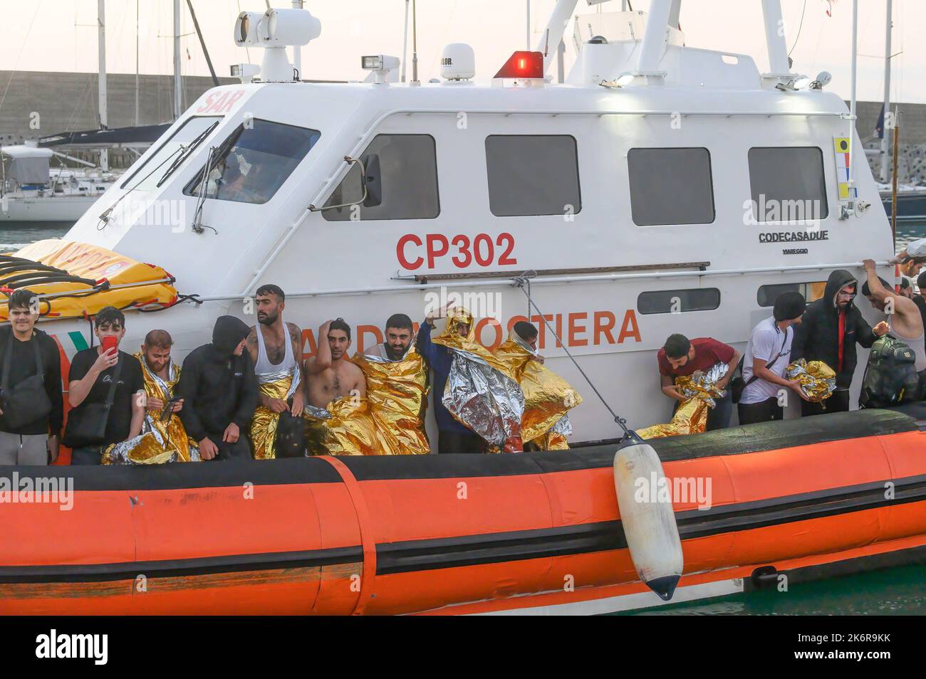 Migrants seen with thermal blankets on a patrol boat. Patrol boats of ...