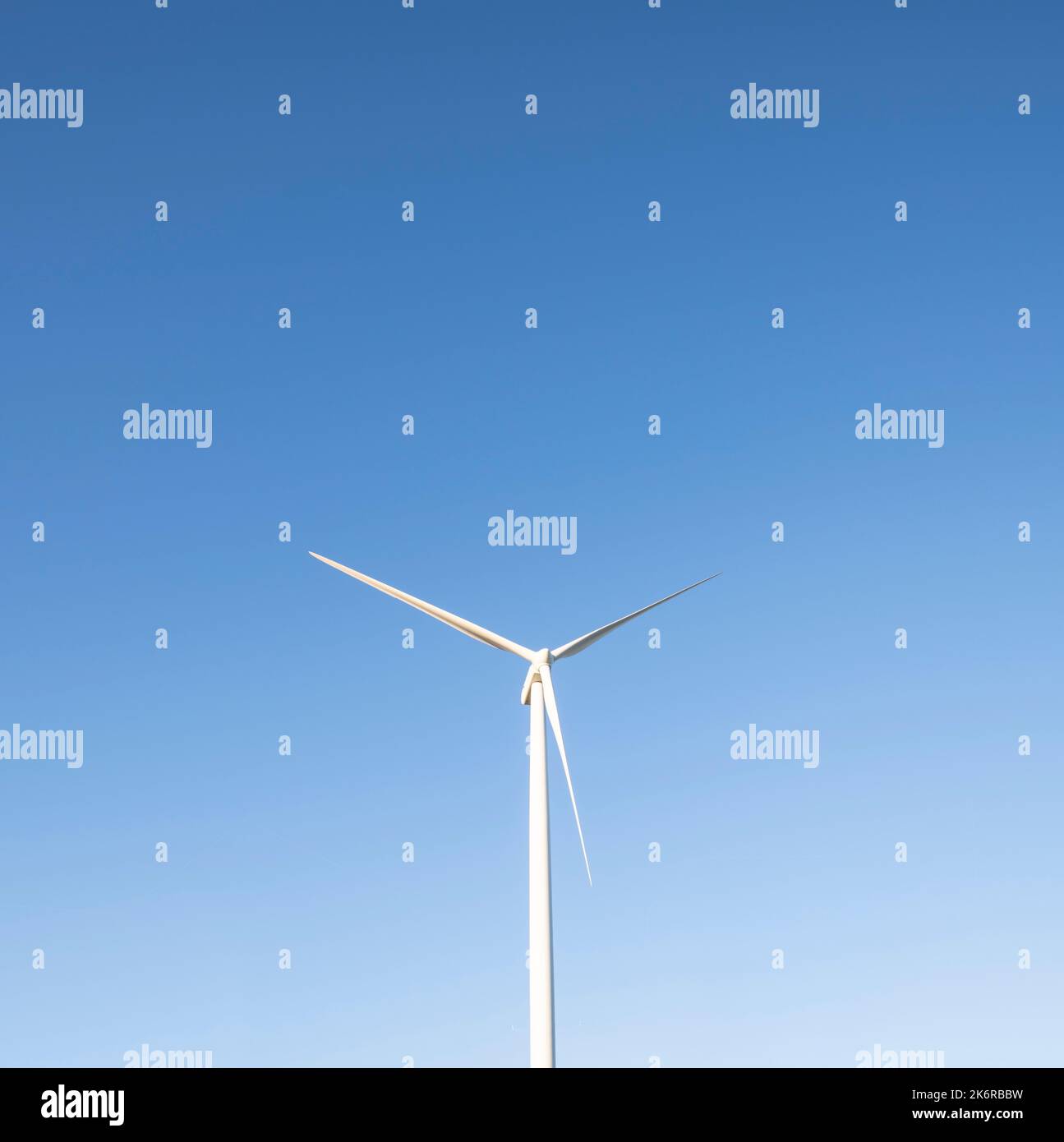 Isolated Wind Turbine against clear blue sky, green technology ...