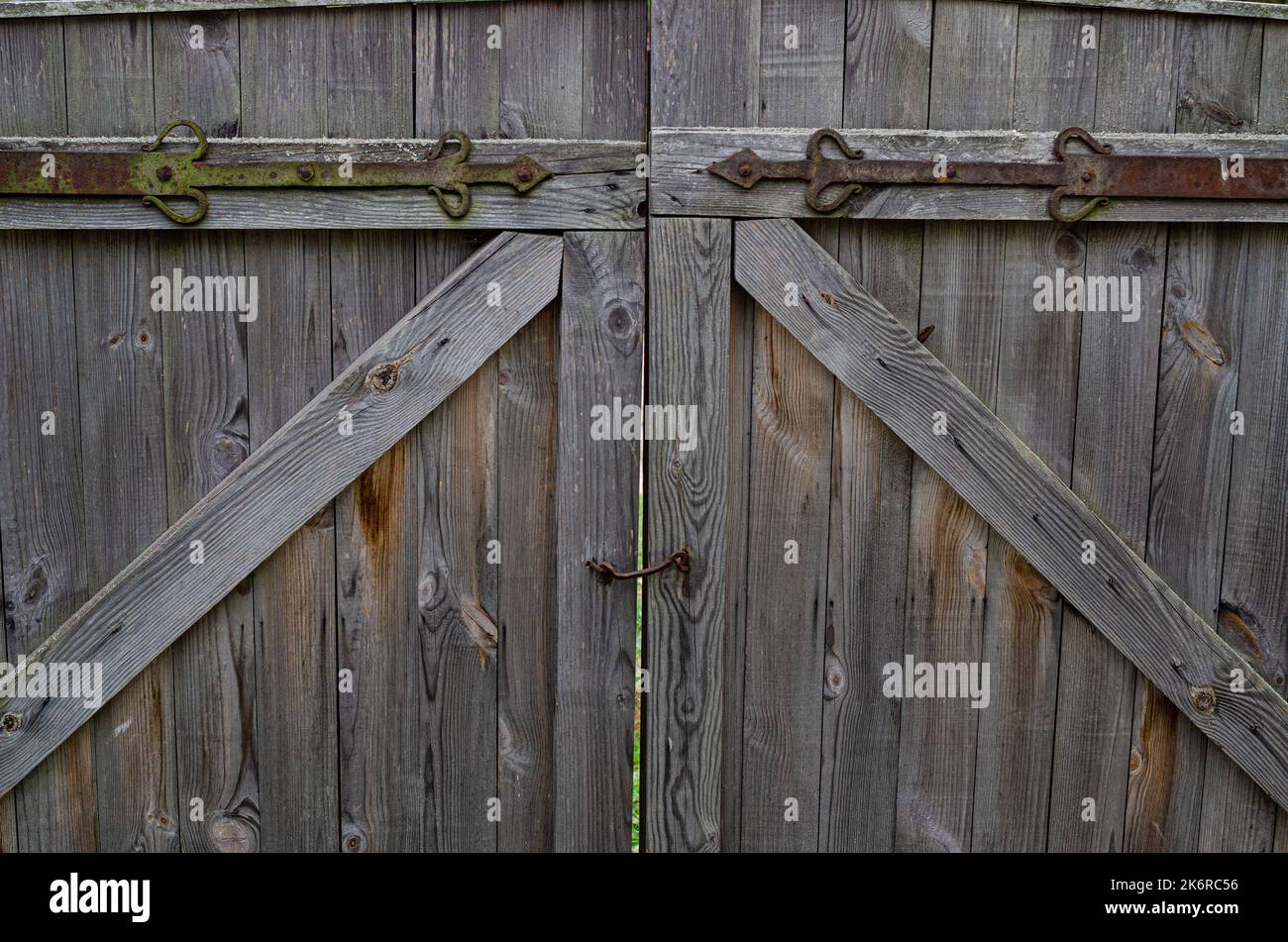 White old weathered door in the wooden wall of an ancient hut ...